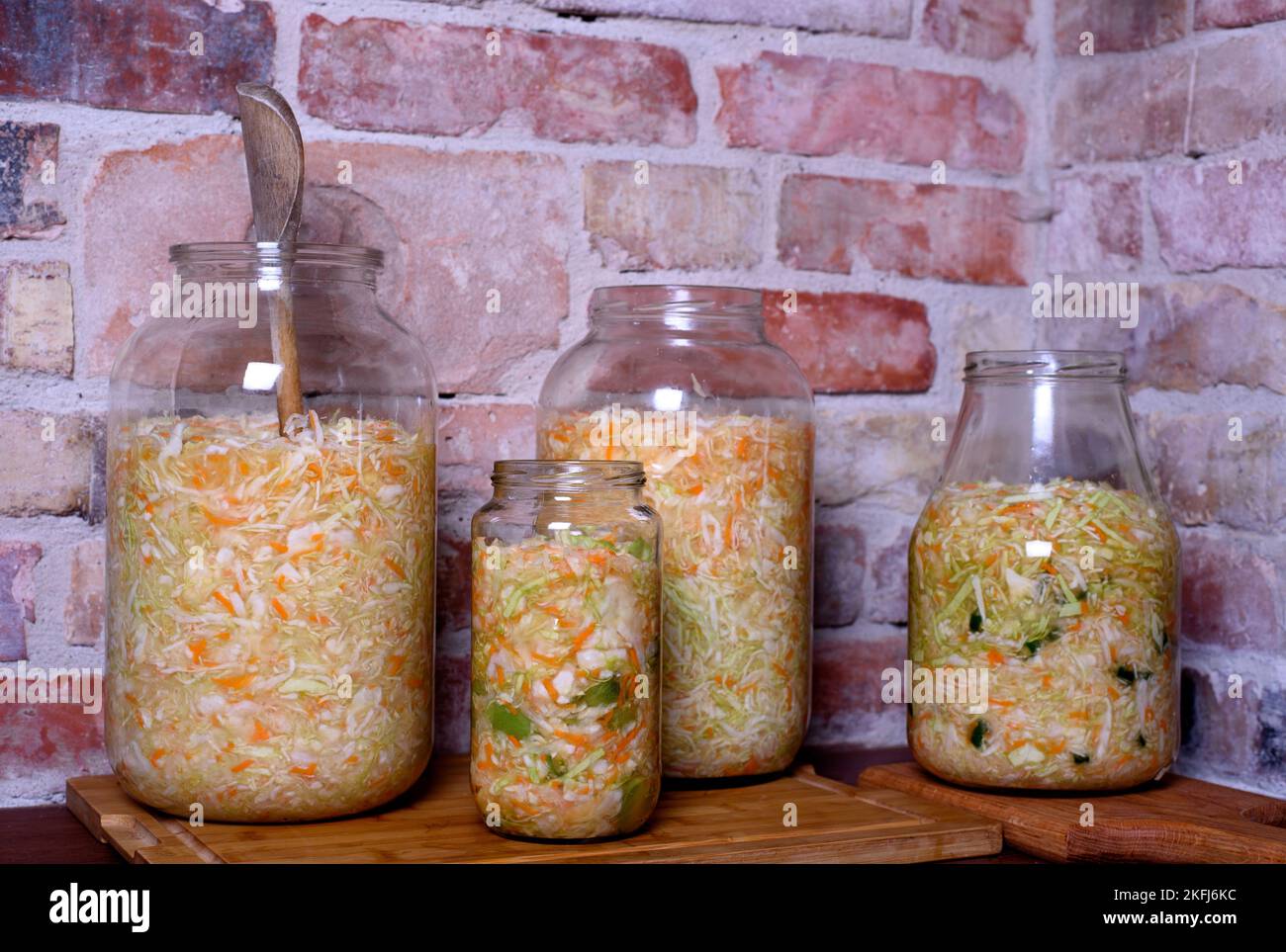 Fermentation preservation Sauerkraut in glass jars, brick background ...