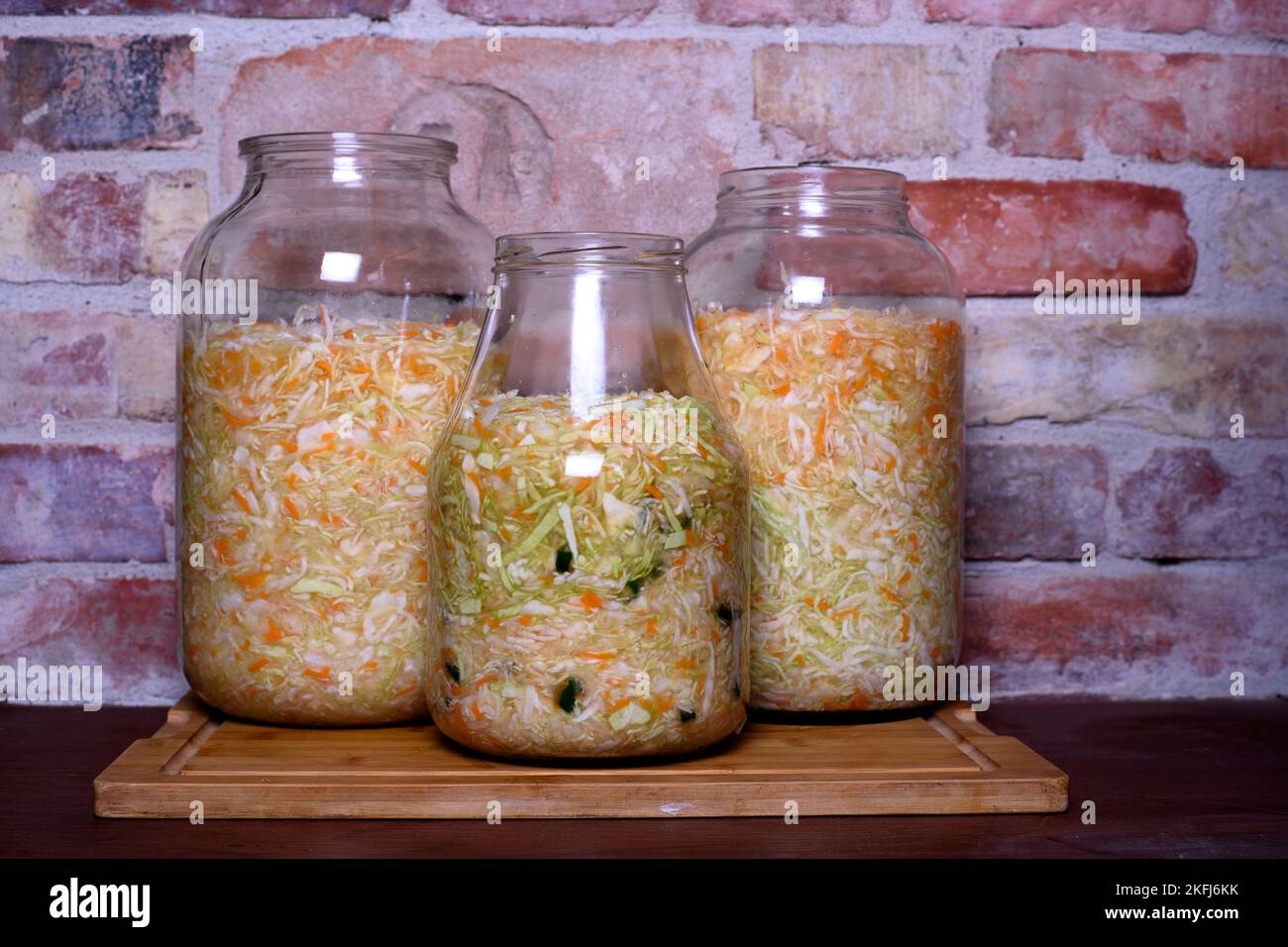 Fermentation preservation Sauerkraut in glass jars, brick background ...