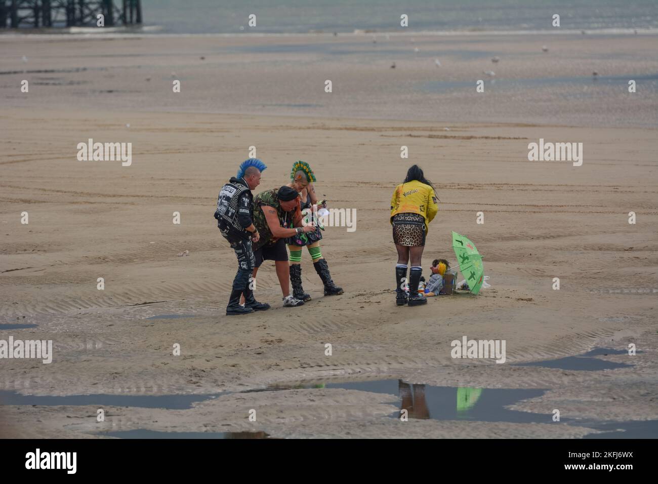 Punk Rockers on the beach using dolls for a photo shoot Stock Photo - Alamy