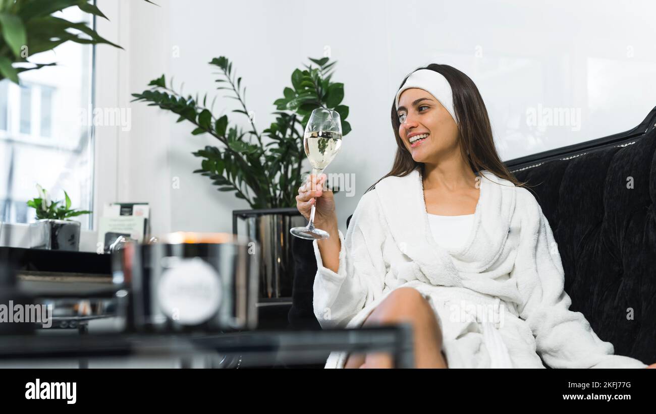 beautiful young Latin woman wearing a white robe sitting on the black ...