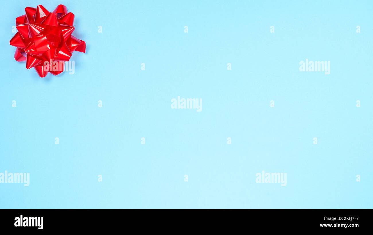 Beautiful Christmas red present ribbon bow over light blue background ...