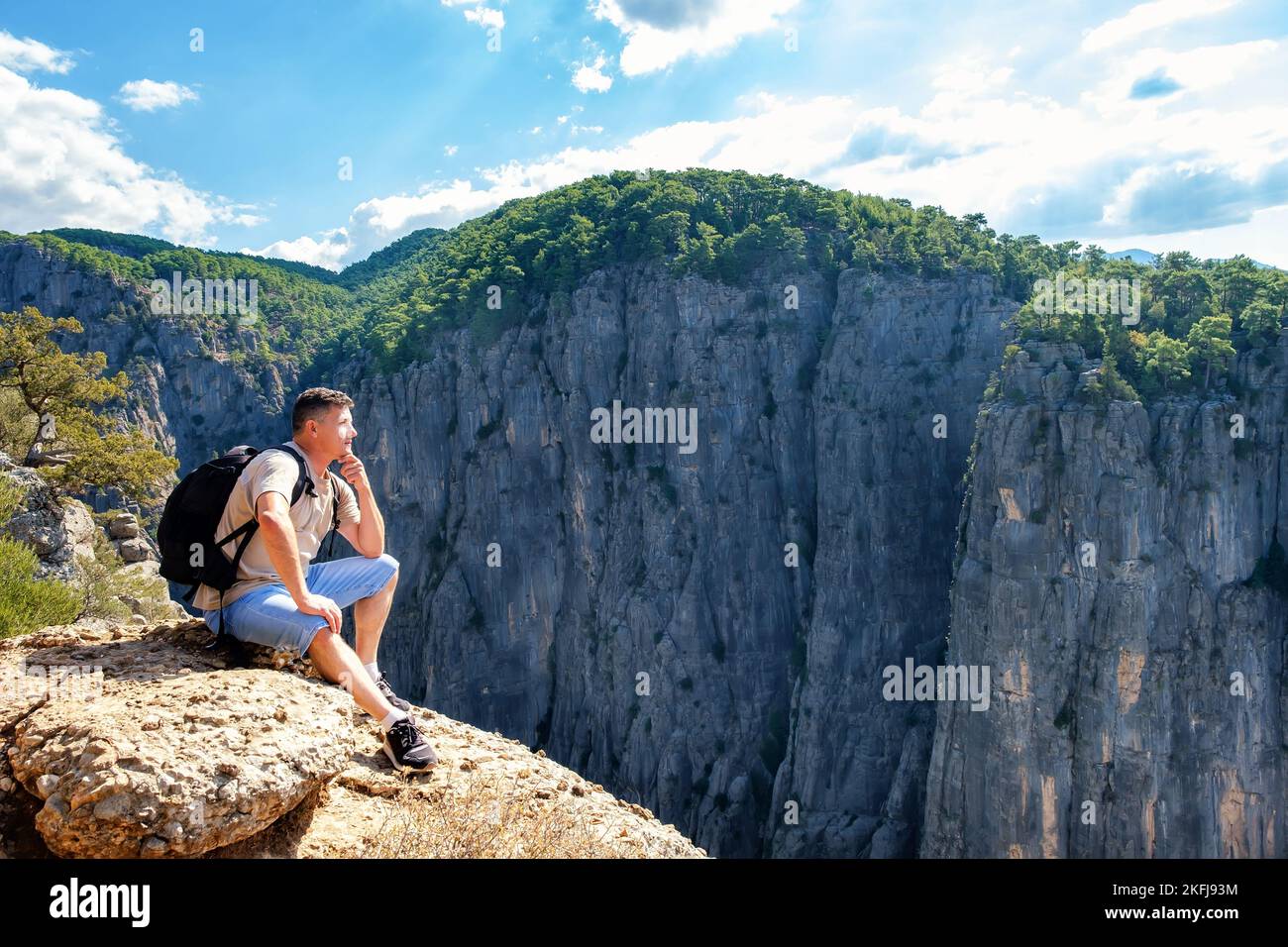 Man sitting rock cliff hi-res stock photography and images - Alamy