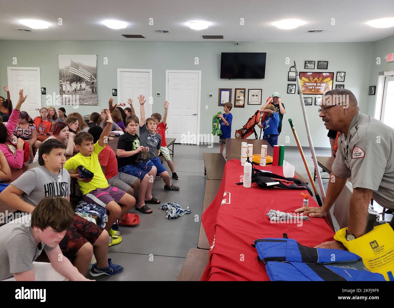 Campers enthusiastically raise their hands volunteering to try on ...