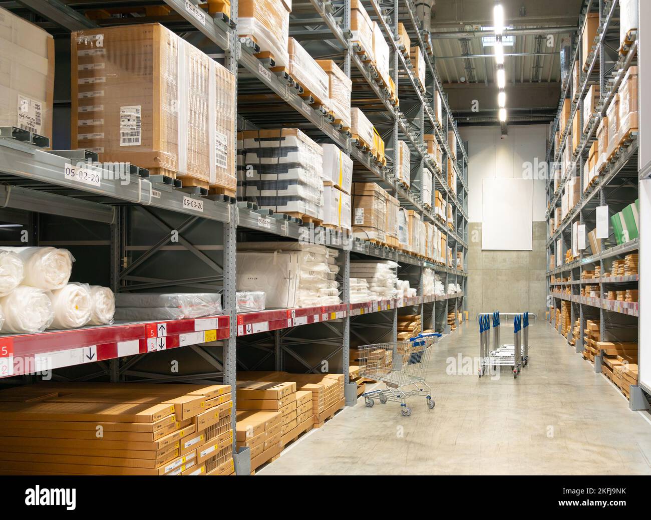 Random shopping carts in a large warehouse in the aisle between shelves ...
