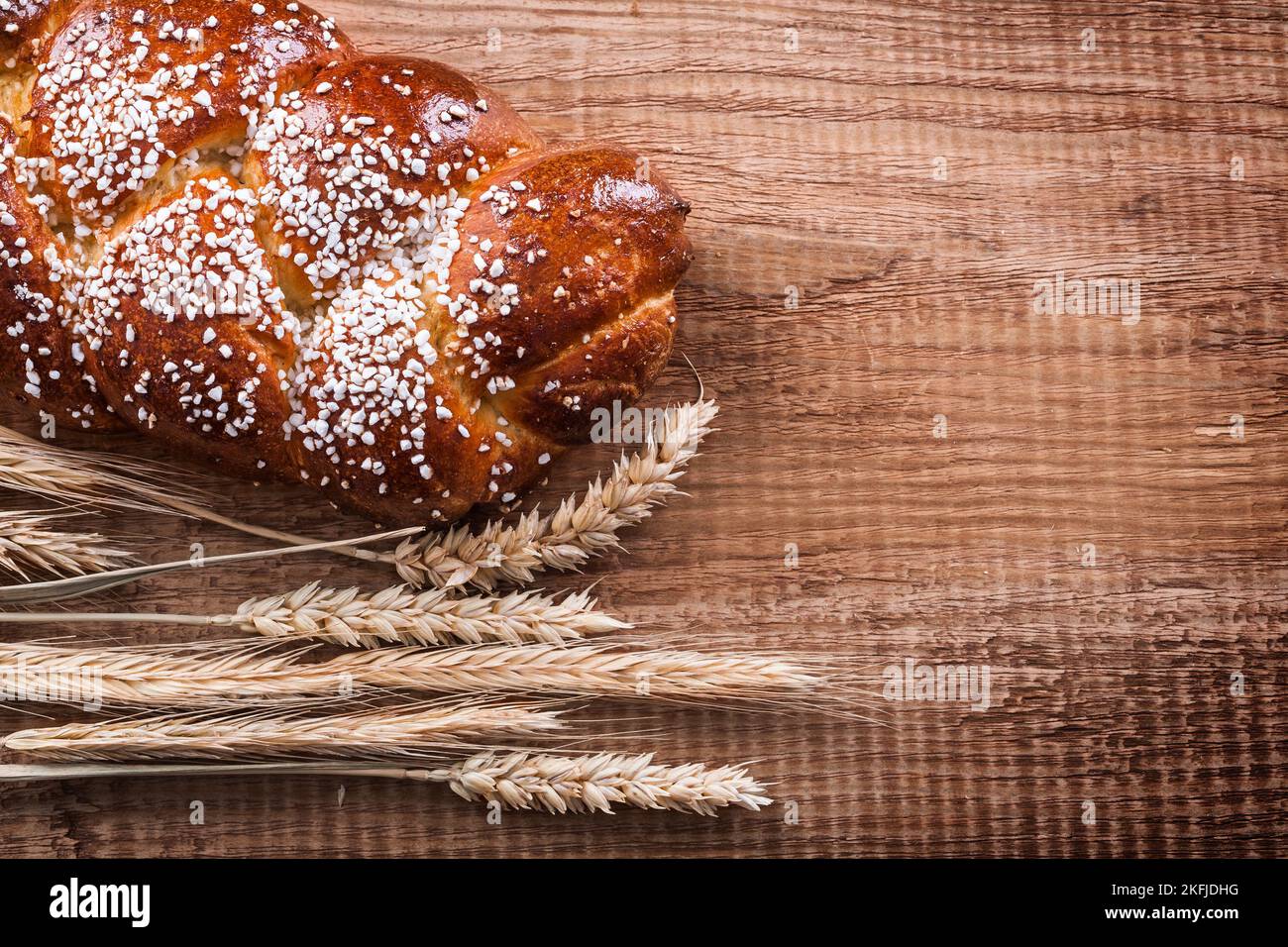 Bunch of wheat ears crusty roll on oak wooden board food and drink ...