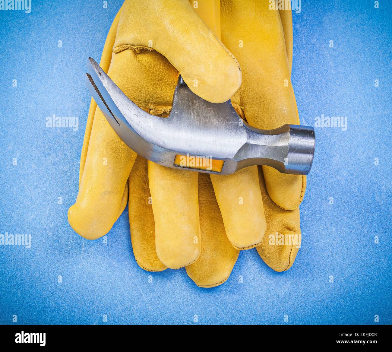 Composition of claw hammer protective gloves on blue background ...