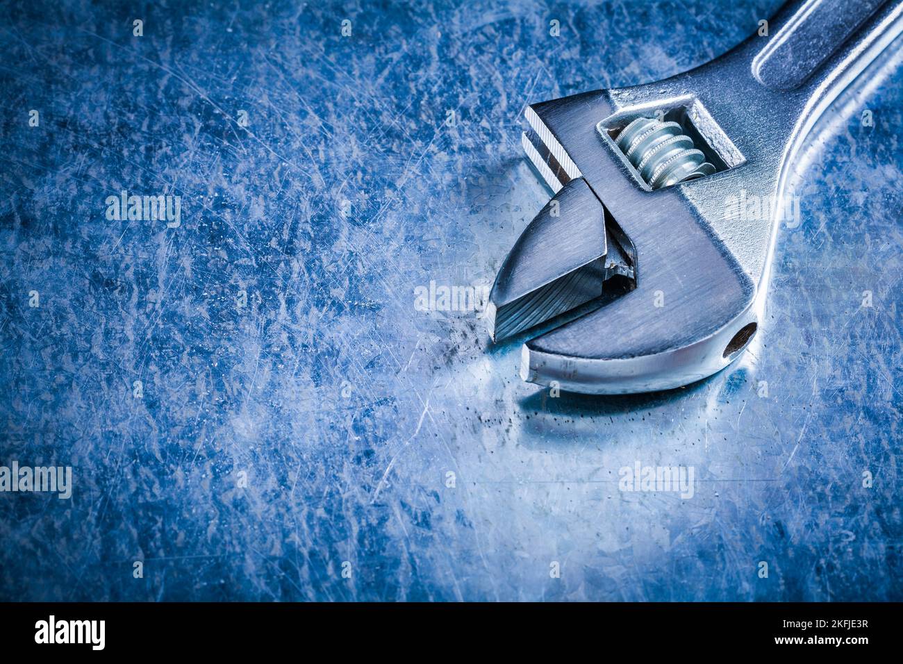 Copy space of stainless adjustable wrench on scratched metallic ...