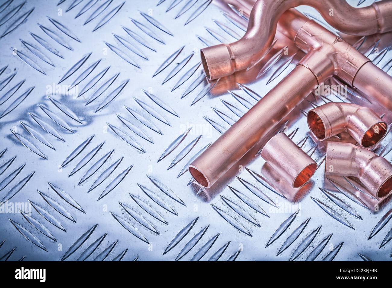 Copper pipe fittings on grooved metal plate plumbing concept Stock ...