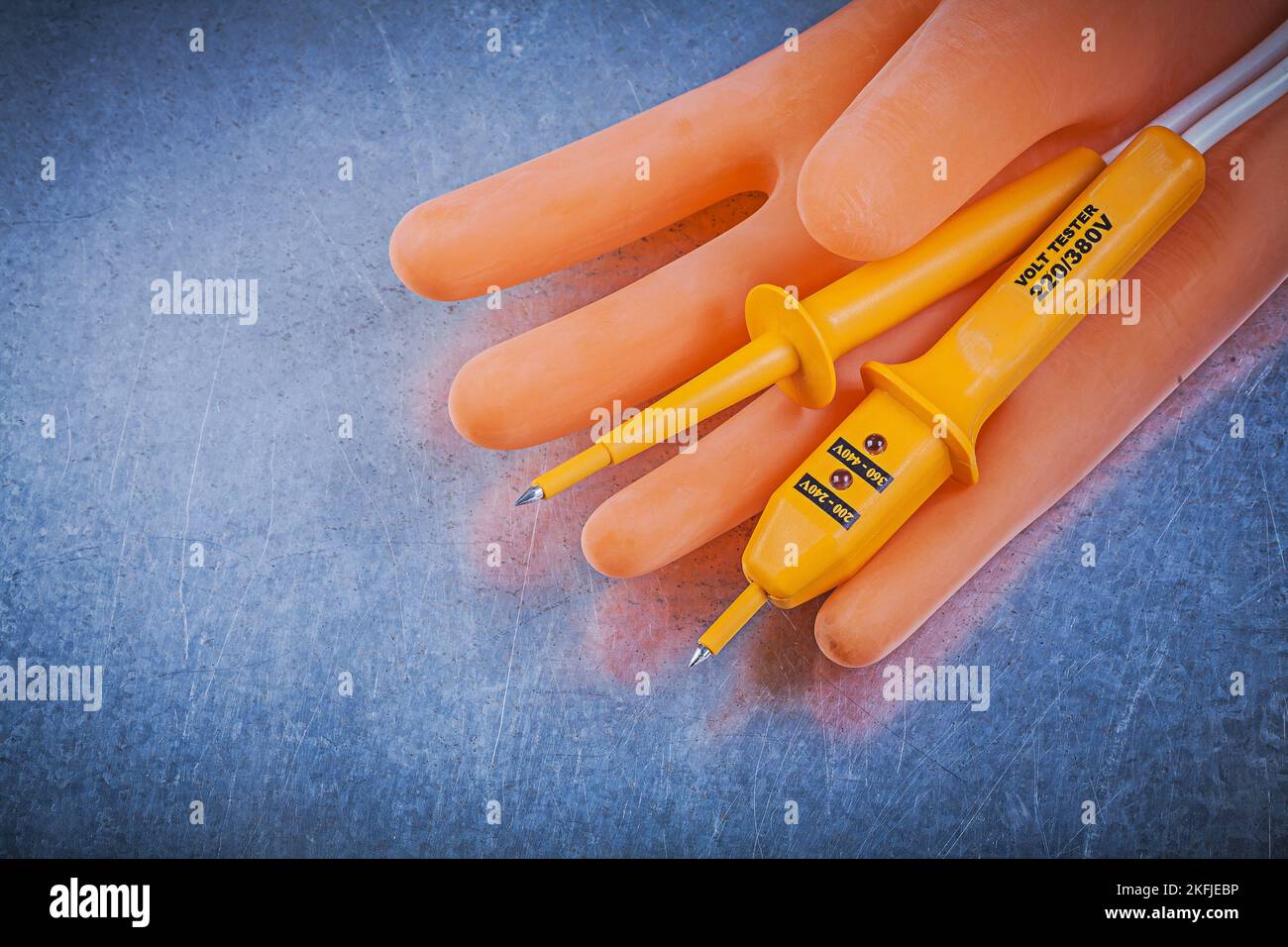 Electricians rubber gloves electric tester on metallic background Stock ...