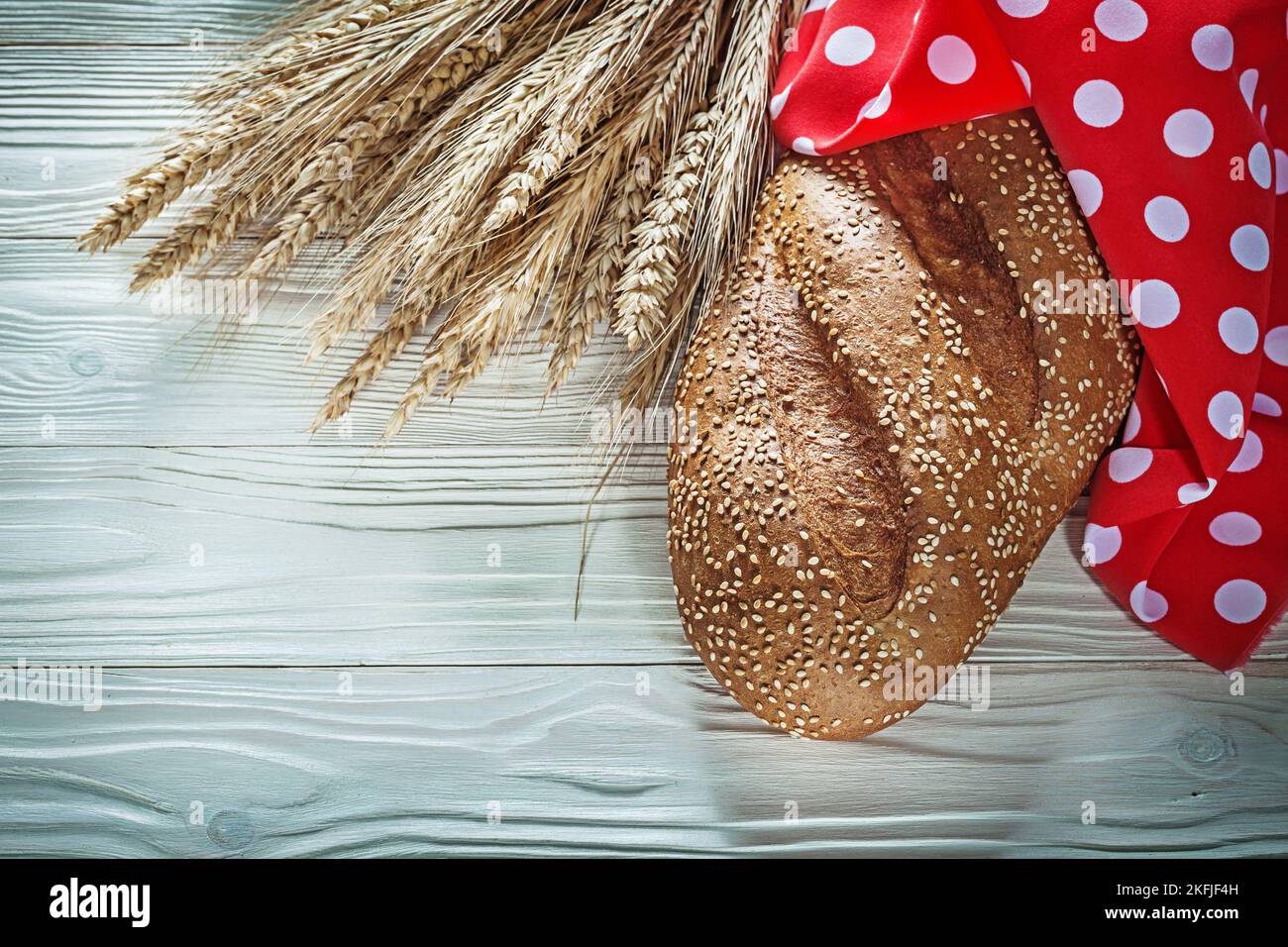 Loaf of bread polka-dot napkin wheat ears on vintage wooden board Stock ...