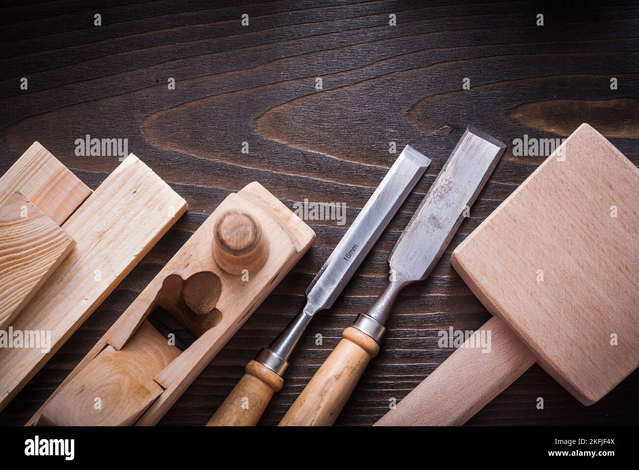 Lump hammer planer firmer chisels and wooden planks on brown hardwood ...