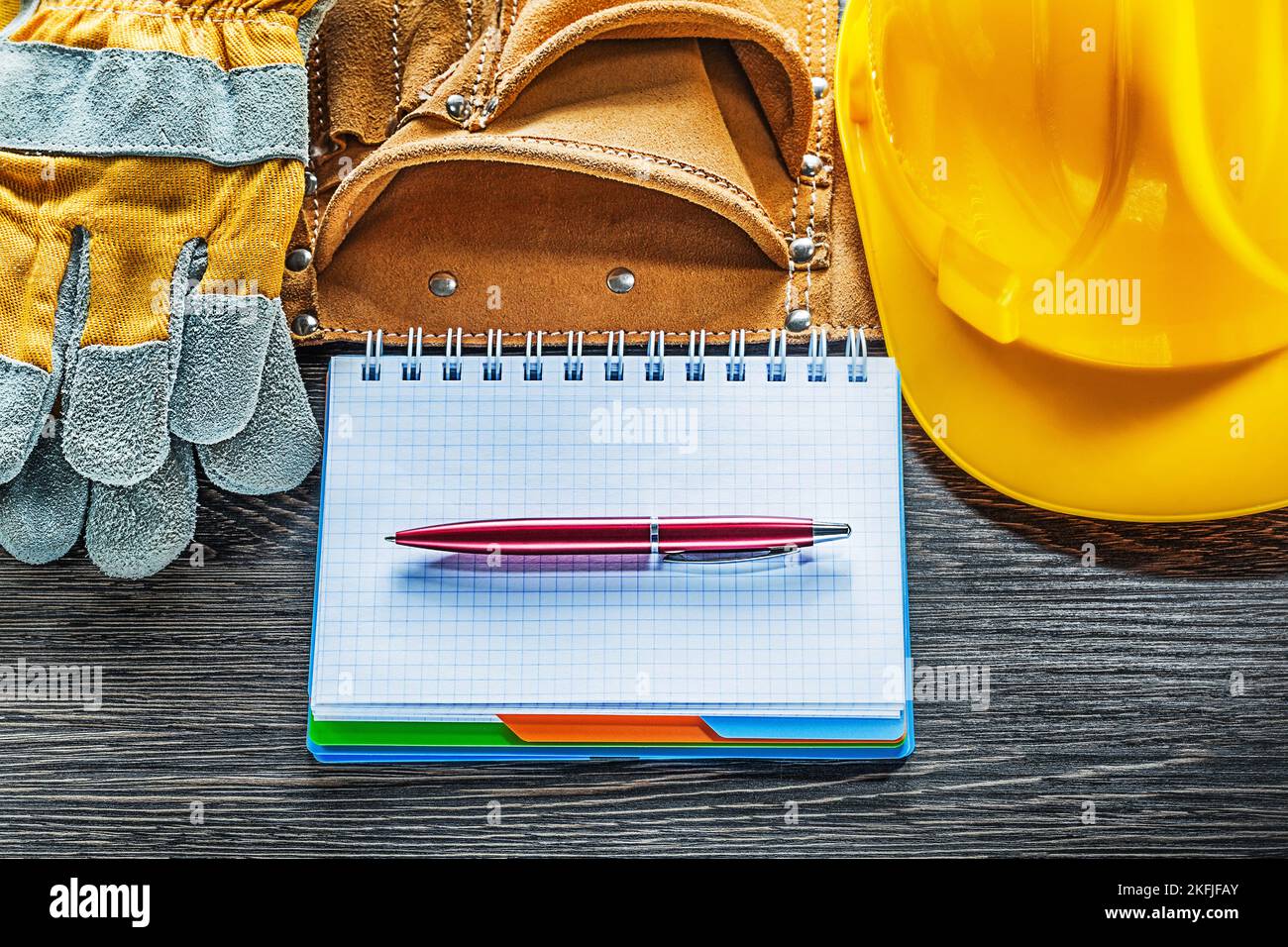 Notepad pen tool belt safety gloves hard hat on wooden board Stock ...