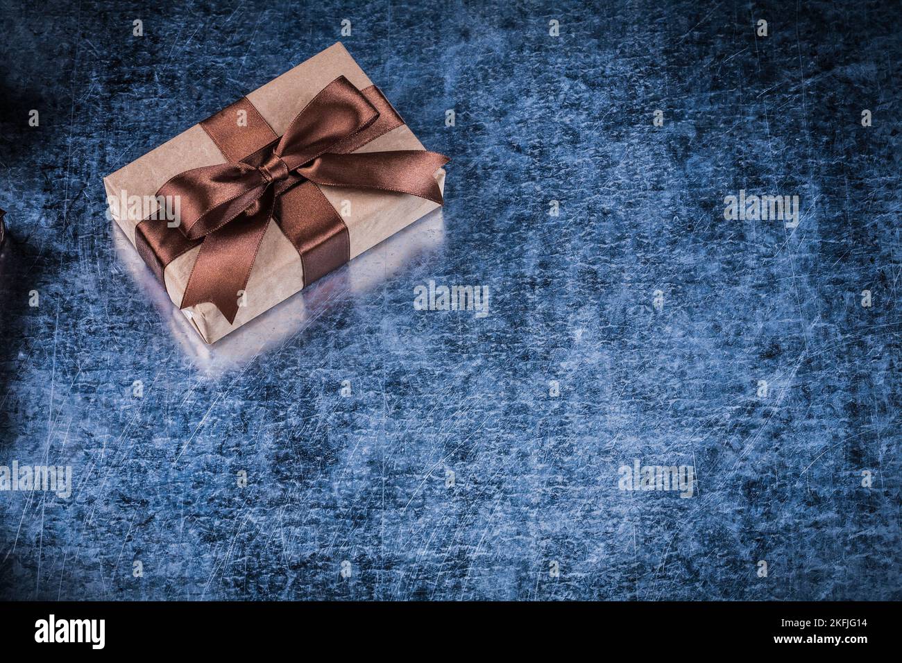 Present box with bow on scratched metallic background holidays concept ...