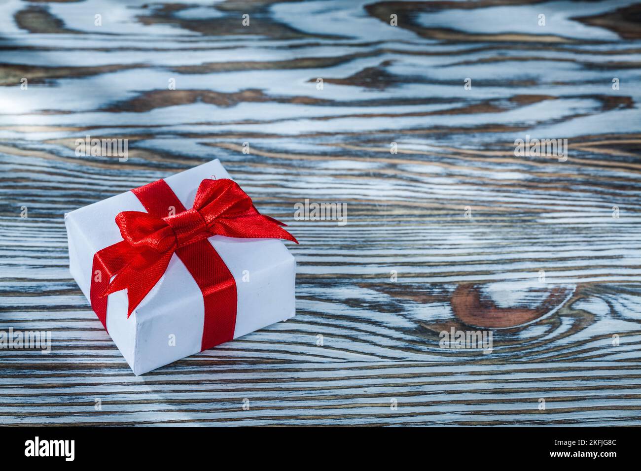 Red present box with knot on wooden background Stock Photo - Alamy