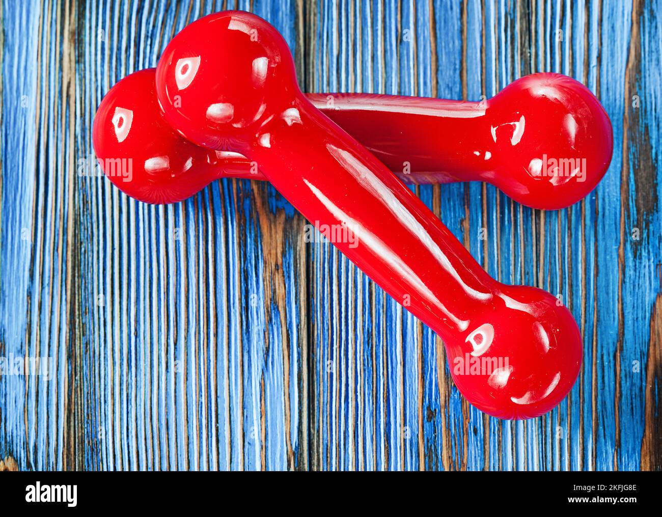 Red dumbbell weights on vintage wooden board Stock Photo - Alamy