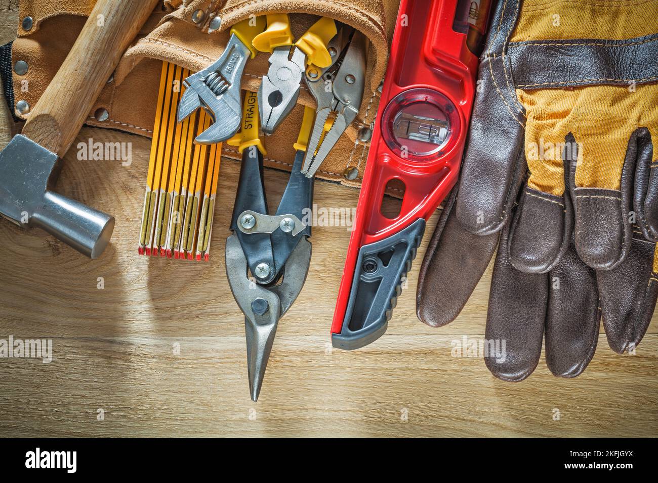 Tool belt with tooling construction level safety gloves on wooden board ...