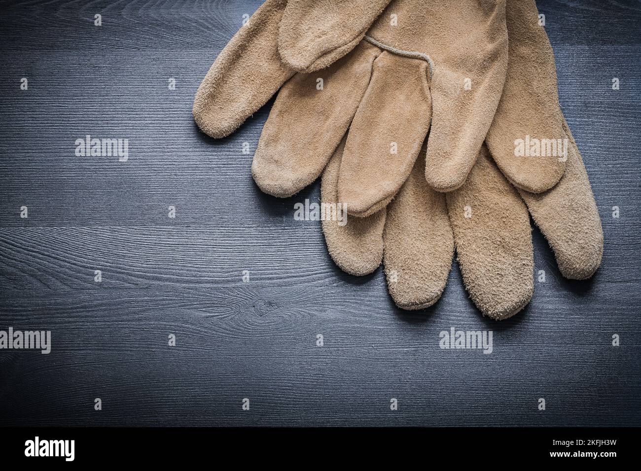 two safety gloves on dark wooden board Stock Photo - Alamy