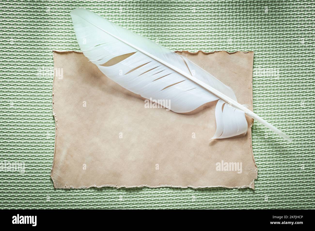 Vintage paper sheet plume on green background top view Stock Photo - Alamy
