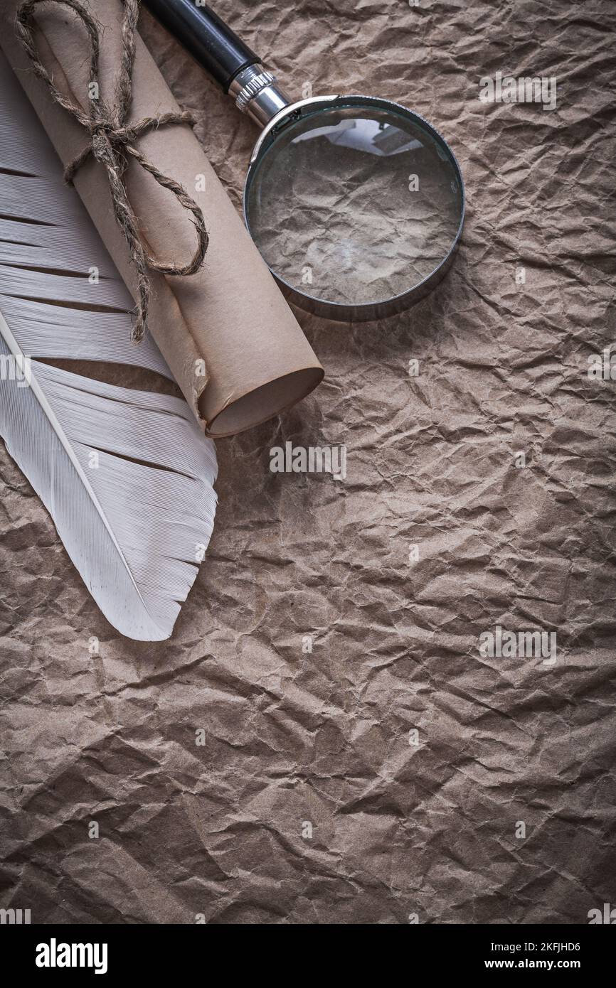 Vintage feather magnifier corded rolled document on messy crumpled ...