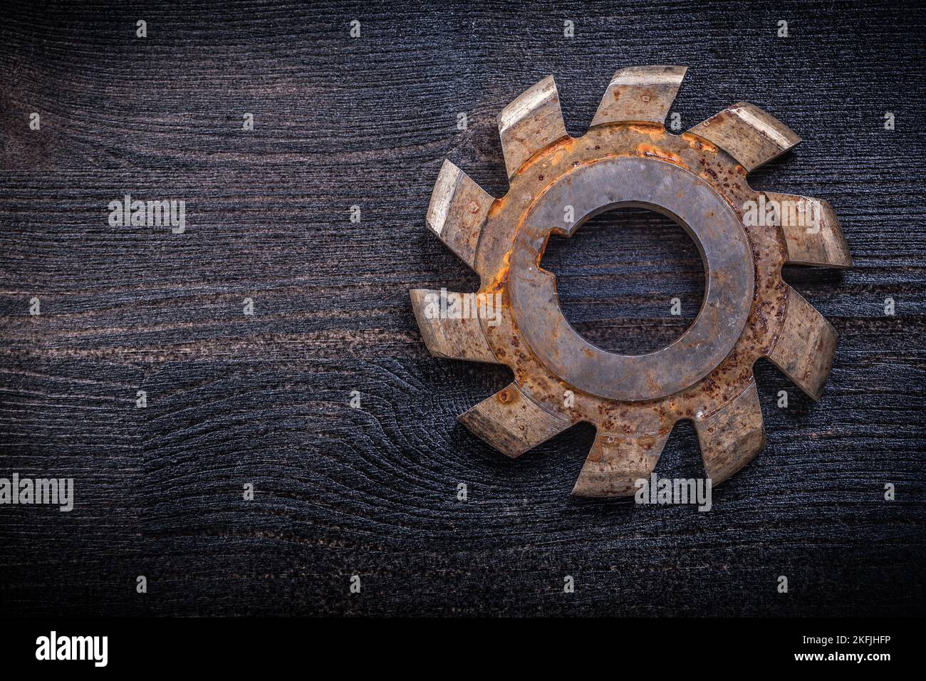 Vintage rotary cutter with cogs on wood board construction concept ...