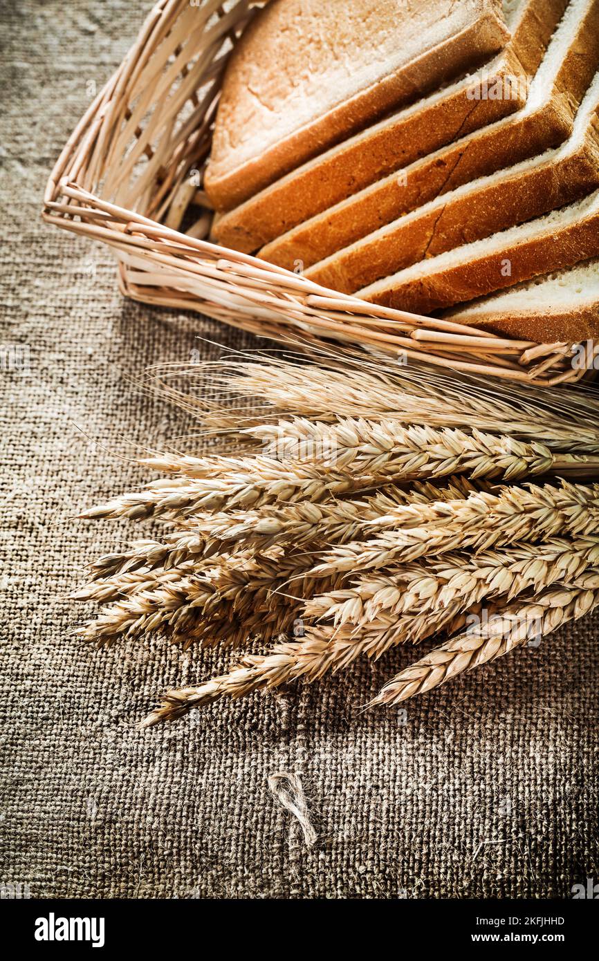 Wicker basket sliced bread rye ears on burlap background Stock Photo ...