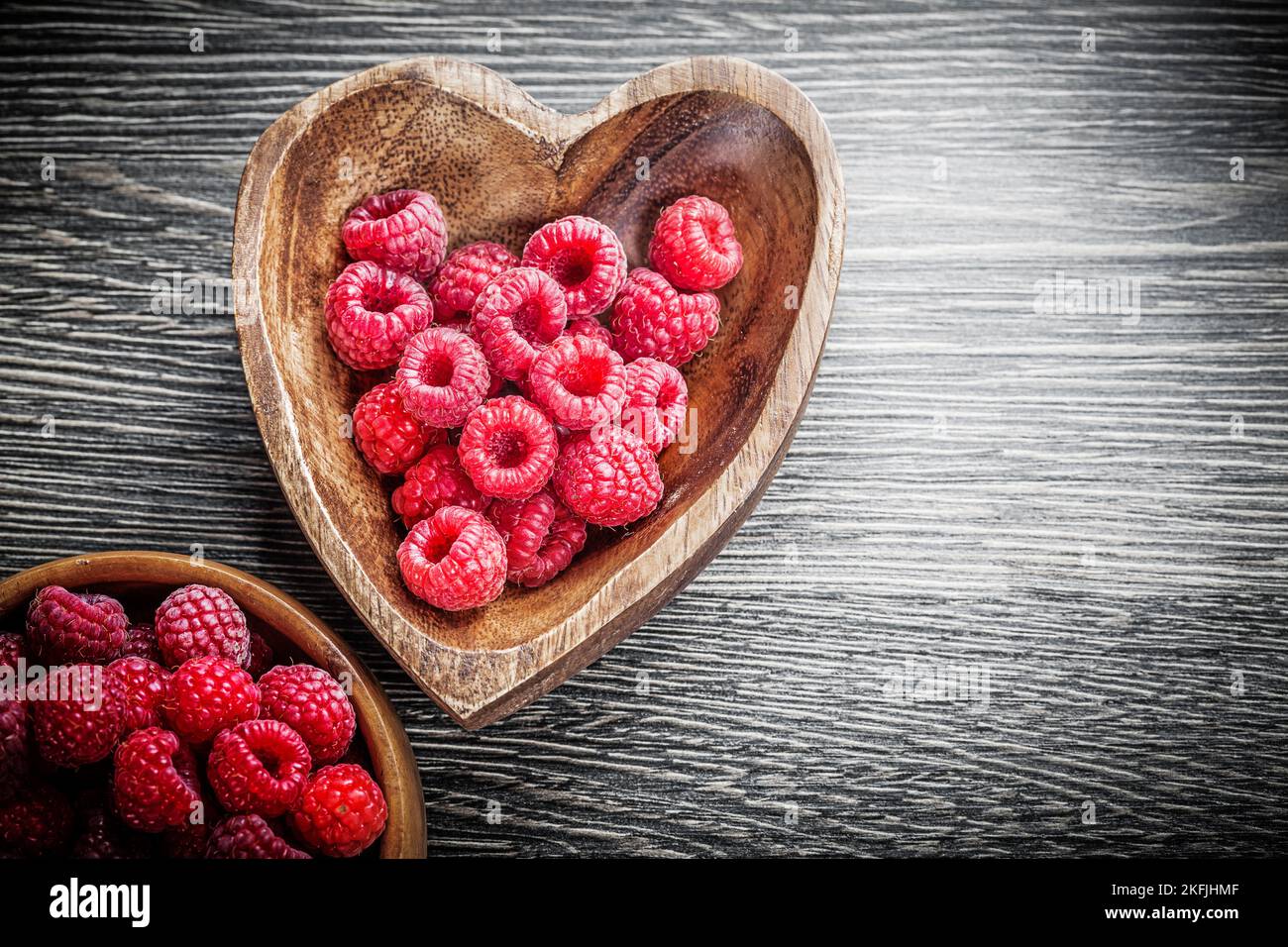 Wooden bowls with ripe raspberries on wood board Stock Photo - Alamy