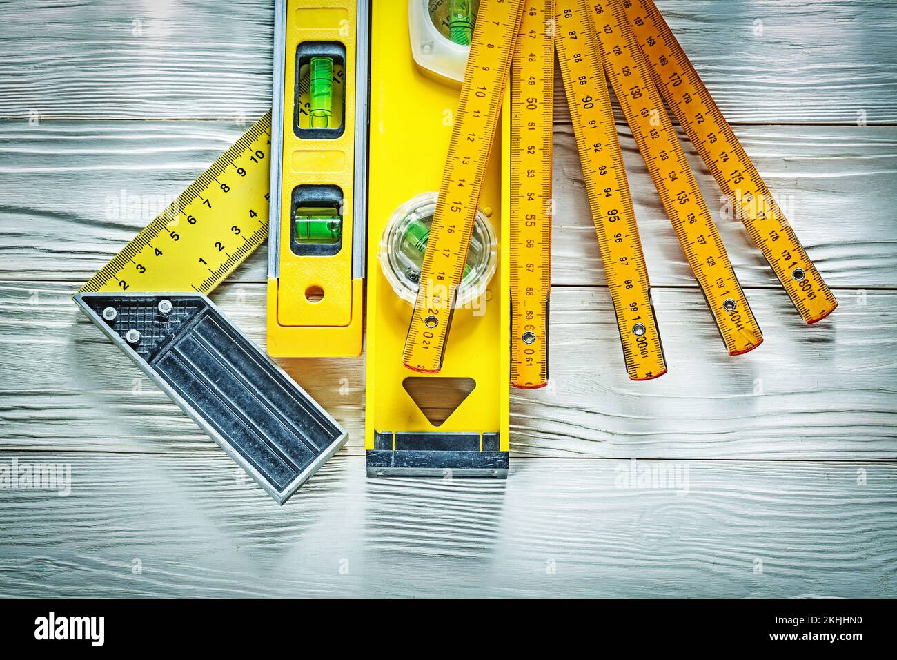 Wooden meter construction level square ruler on white board top view ...