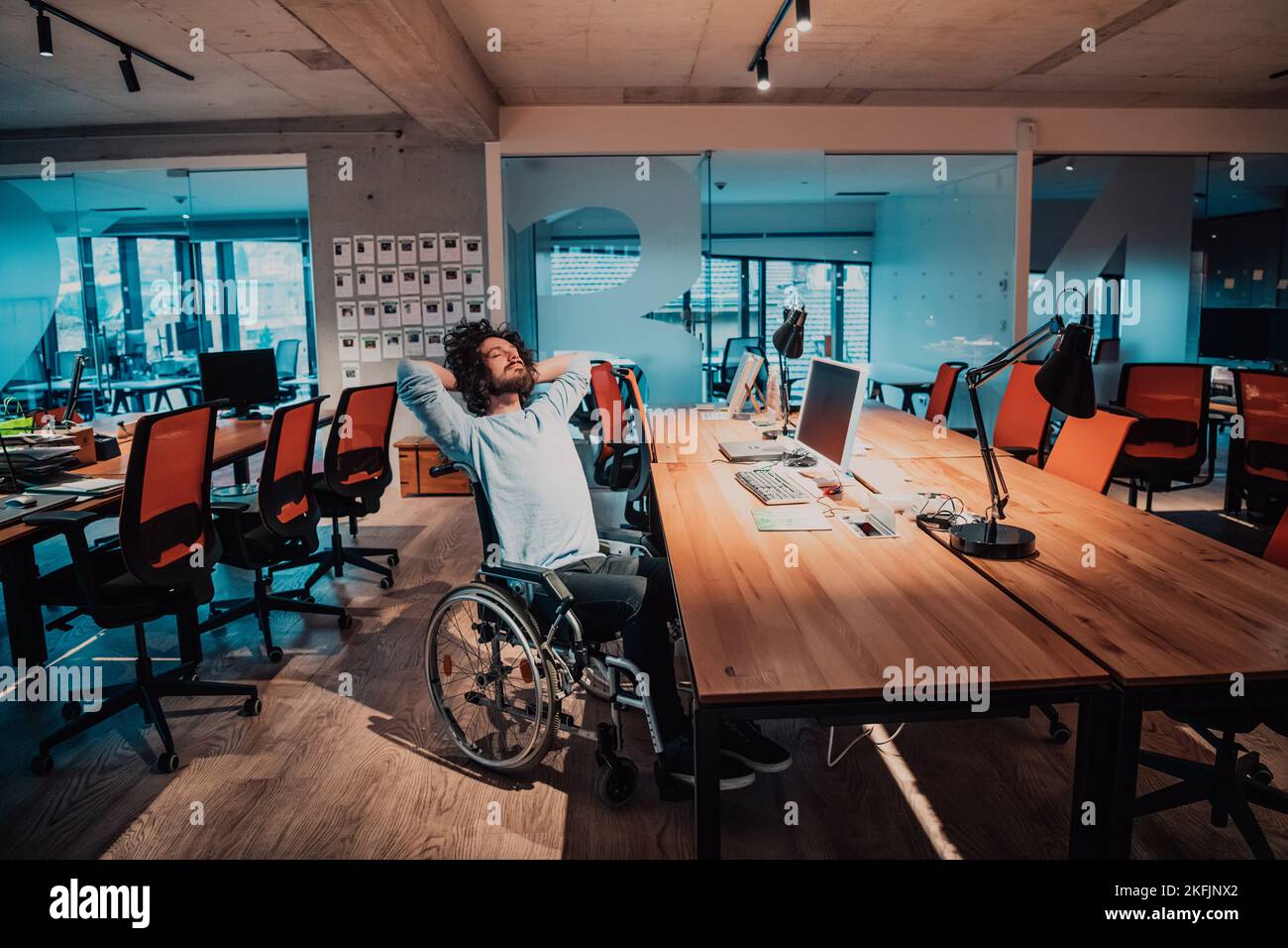 Businessman with a disability in wheelchair working overtime alone at ...
