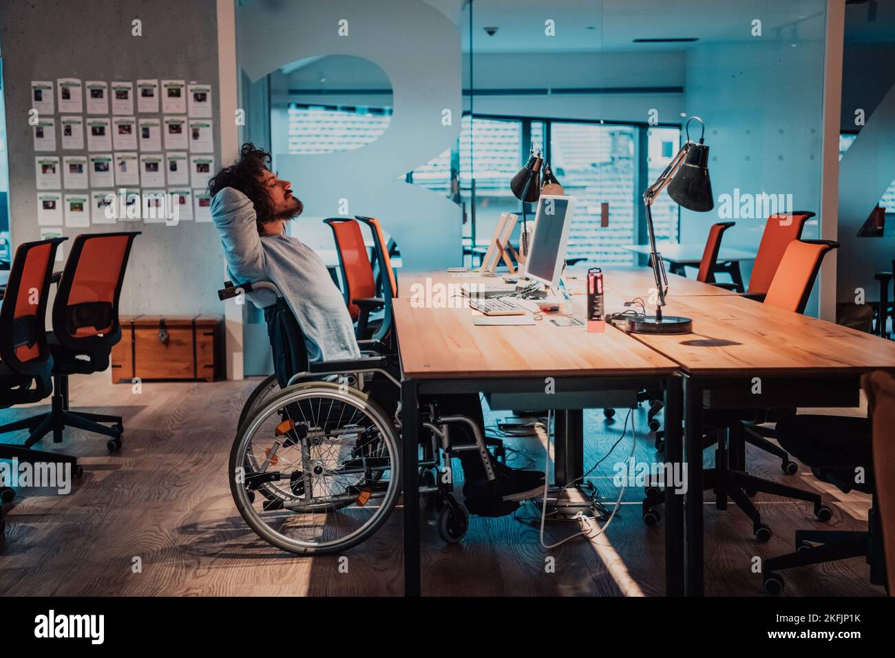 Businessman with a disability in wheelchair working overtime alone at ...