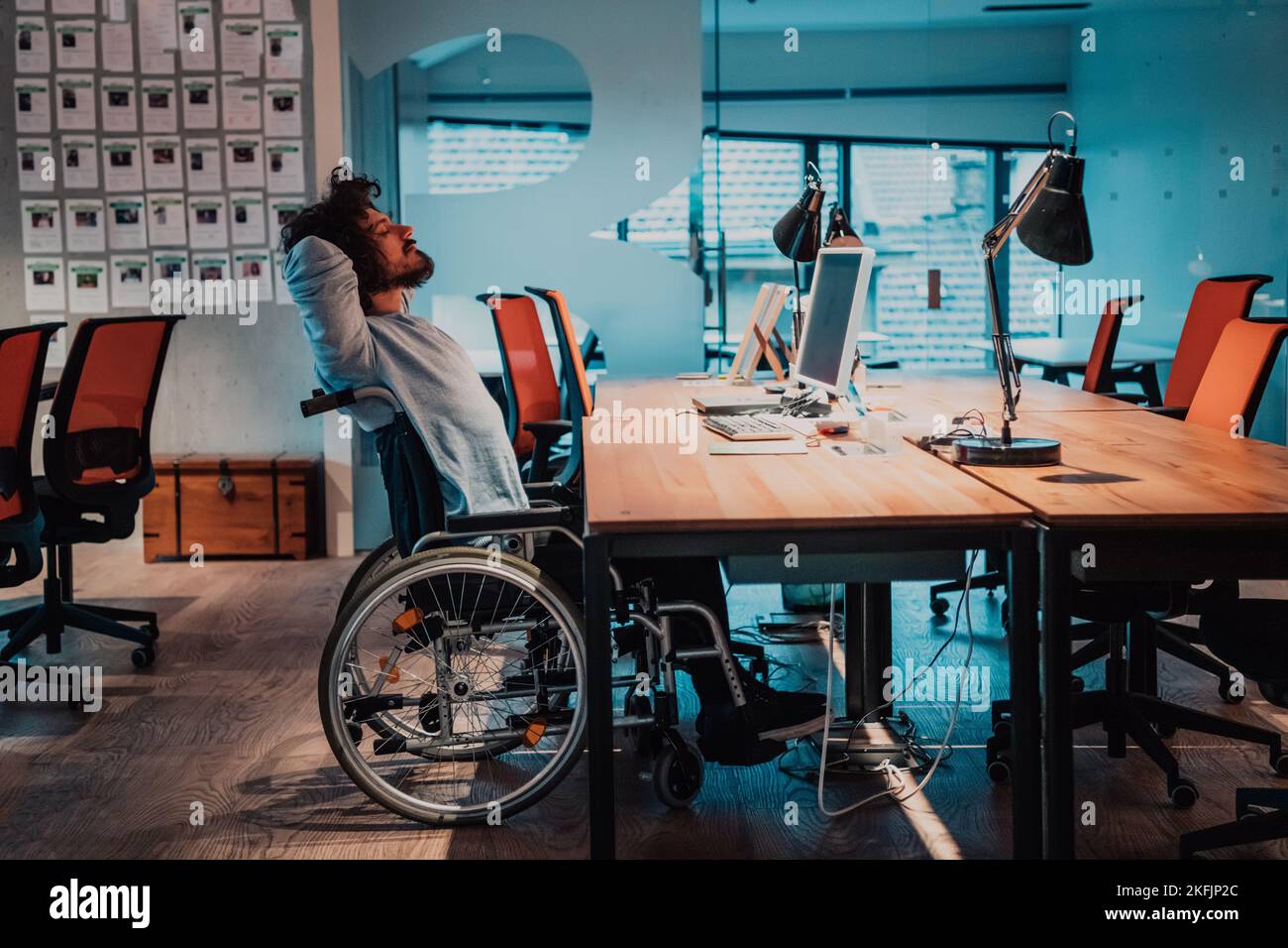 Businessman with a disability in wheelchair working overtime alone at ...
