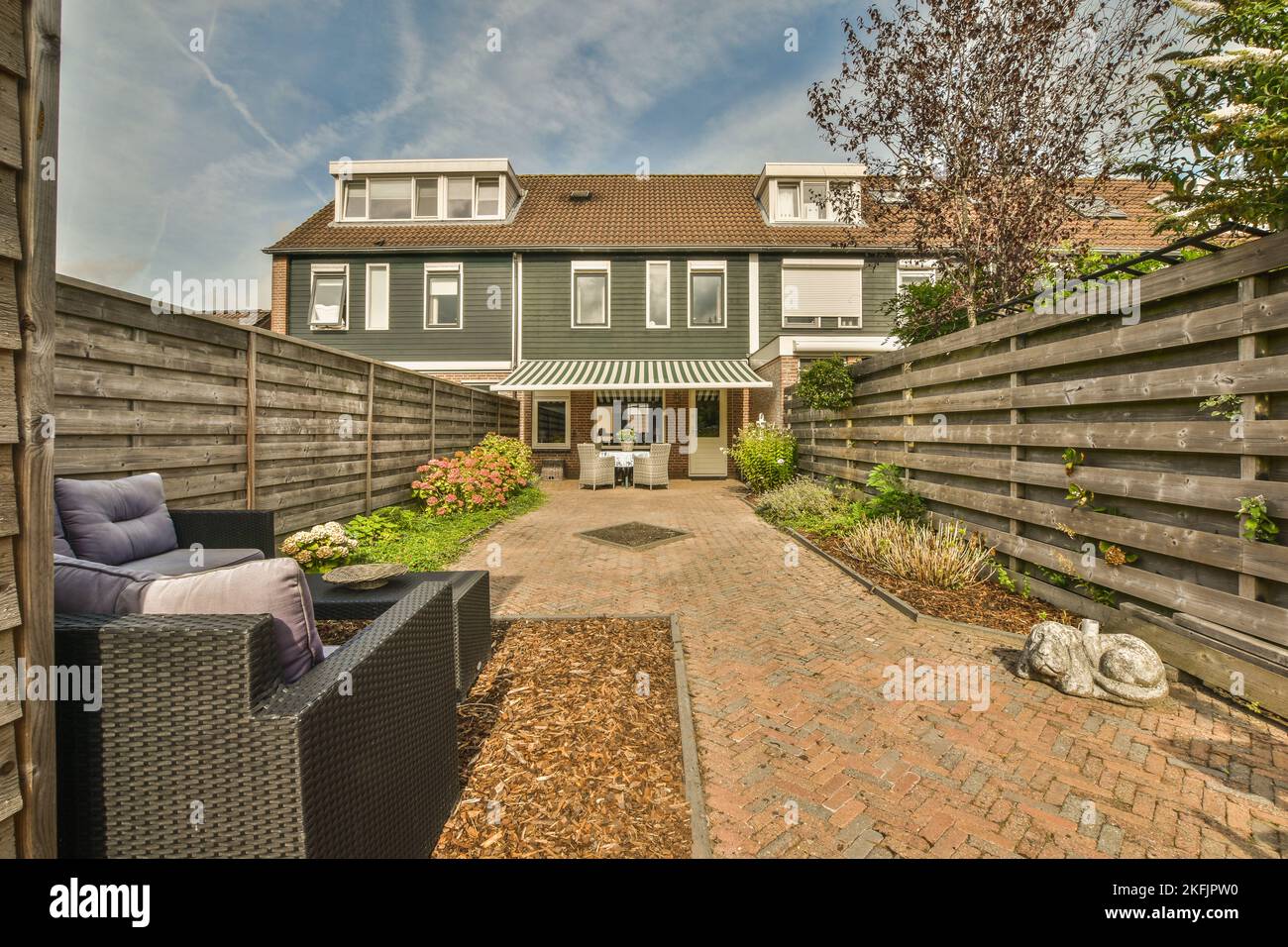 Neat powerful patio with sitting area and small garden near wooden ...