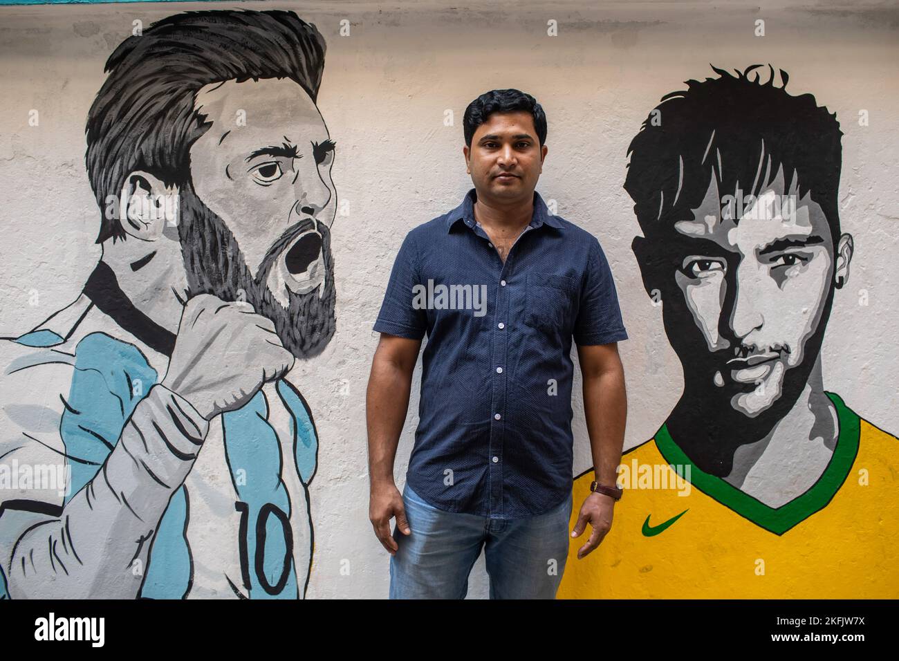 A man poses in front of a graffiti of famous Argentine football players ...