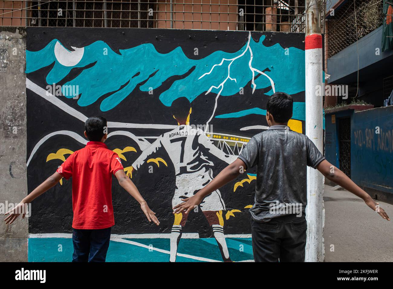 Boys pose in front of a graffiti of famous football player, Cristiano ...