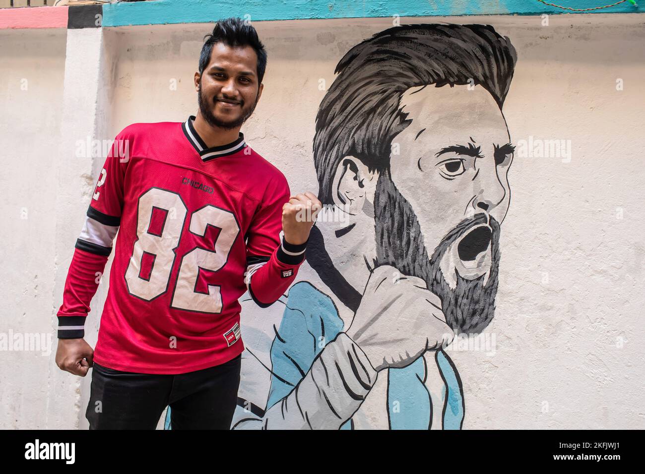 A man poses in front of a graffiti of famous Argentine football star ...