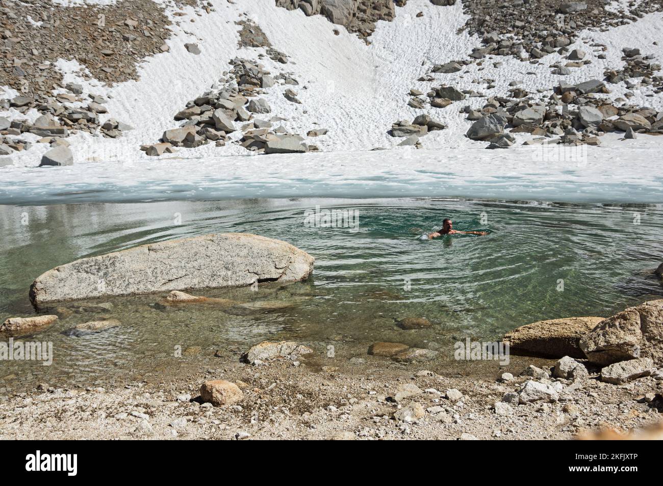 man swimming in cold mountain lake with snow in it Stock Photo - Alamy