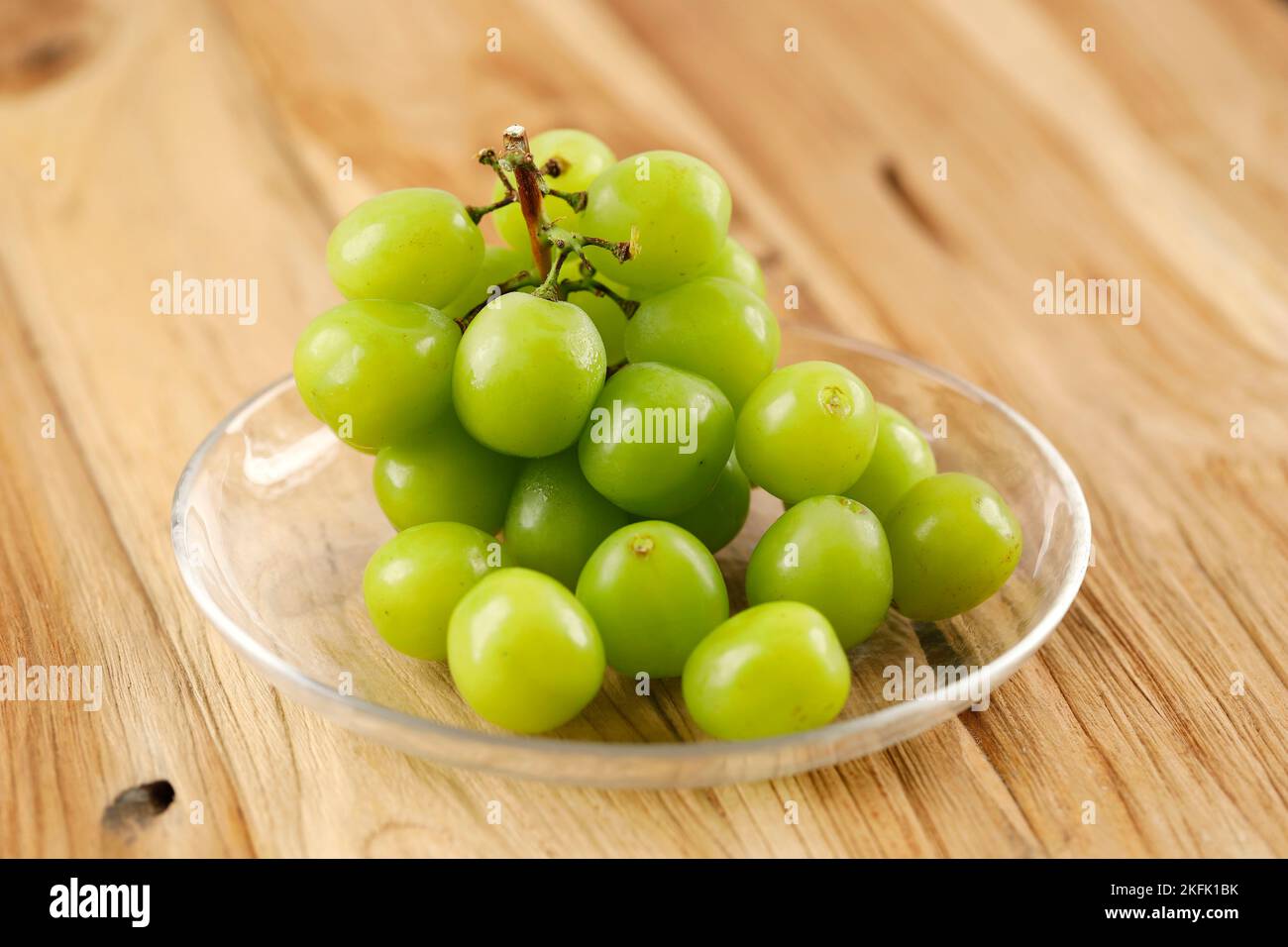 Green Grape in Clear Plate on Wooden Table. Shine Muscat Japanese Grape ...