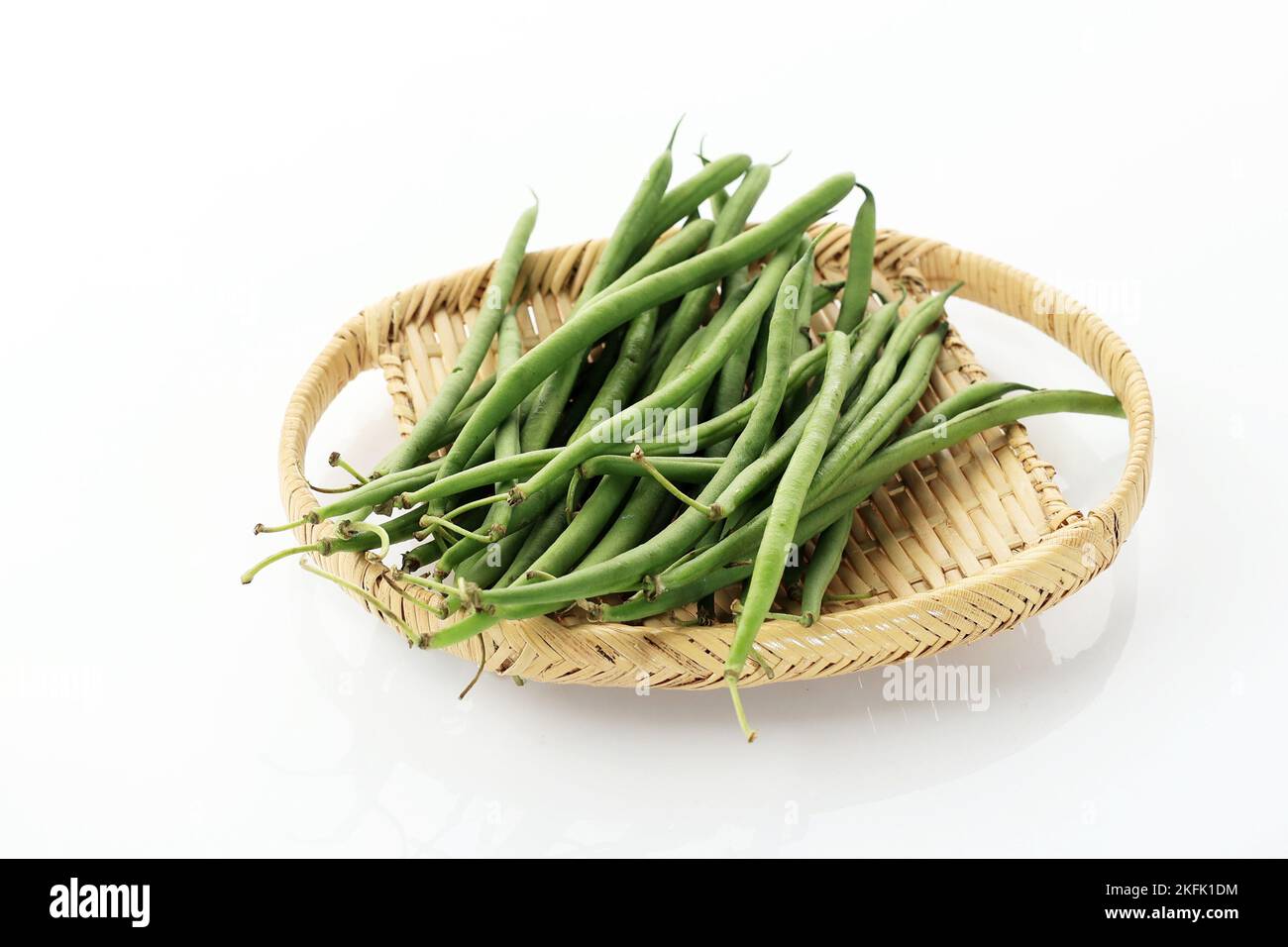 Pile of Raw Green Baby Fine Beans on a Rattan Tray Plate above Isolated ...