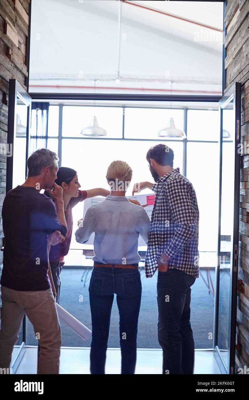 Sharing her plans. A group of colleagues looking over some plans Stock ...