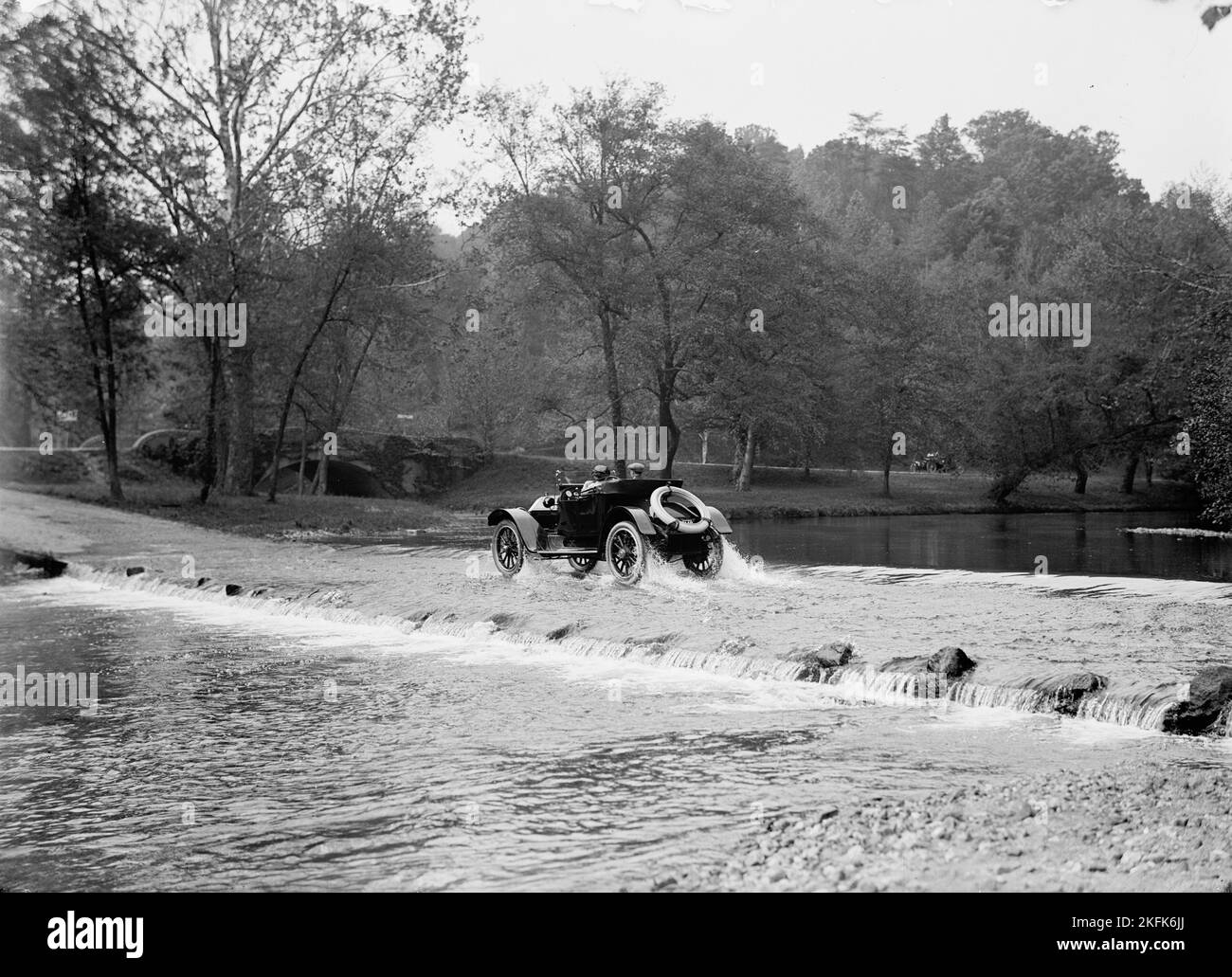 Couple In Automobile Fording A River At A Low Water Crossing Near A ...
