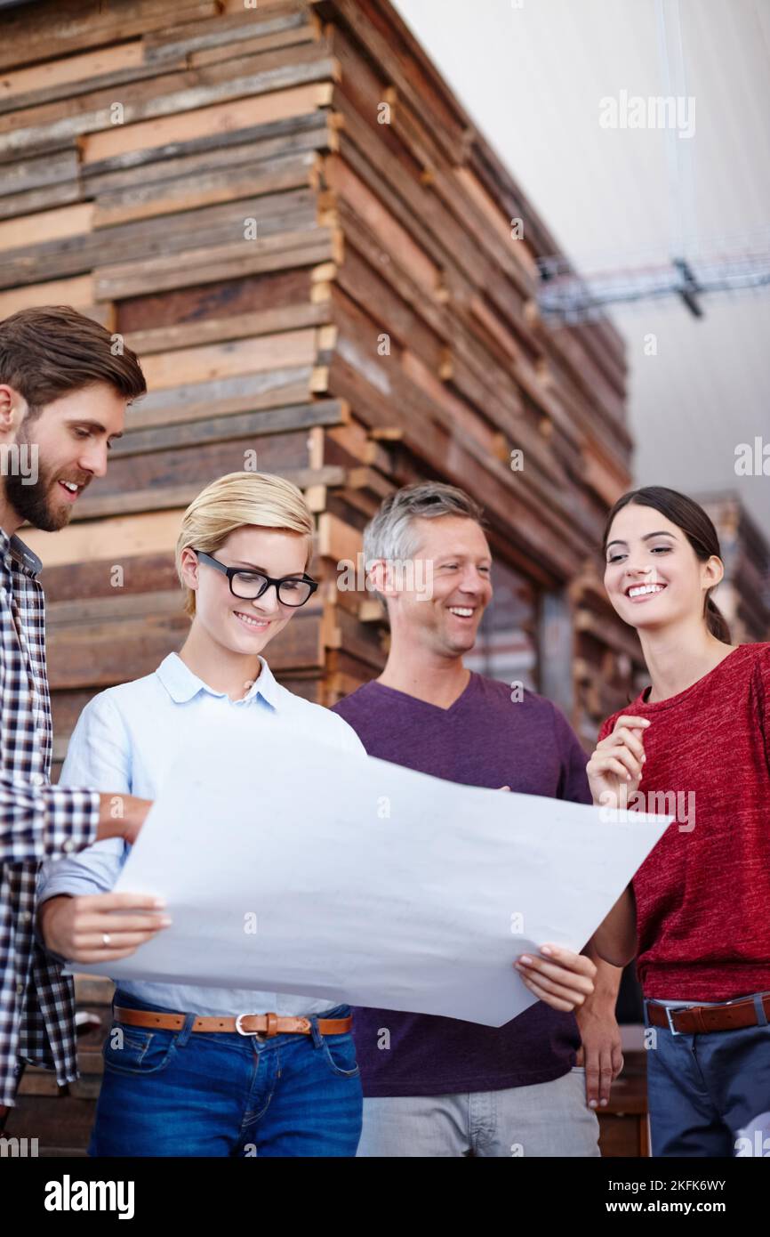 Shes impressed with her plans. A group of colleagues looking over some ...