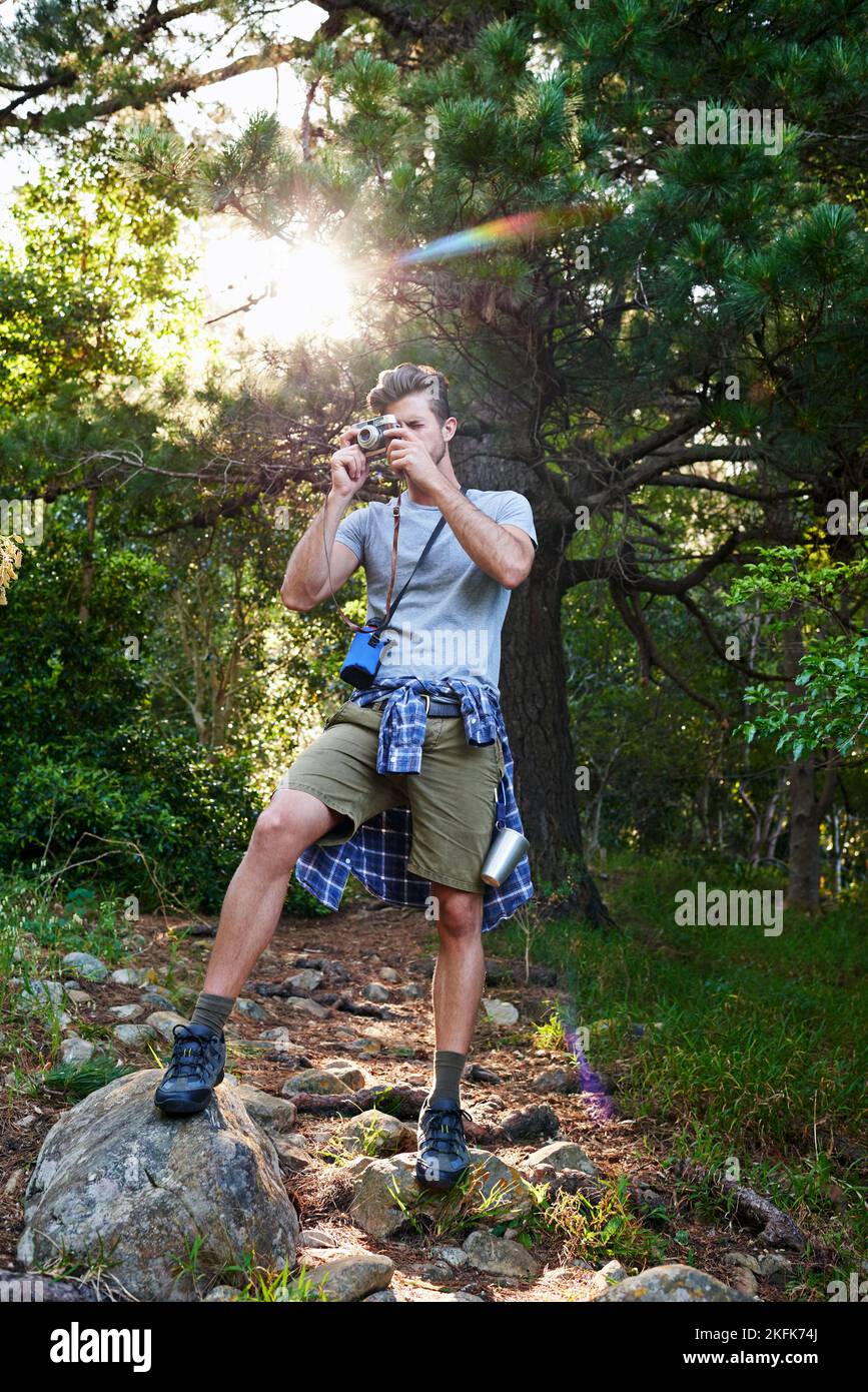 Share the beauty of nature. a handsome man taking pictures of the ...
