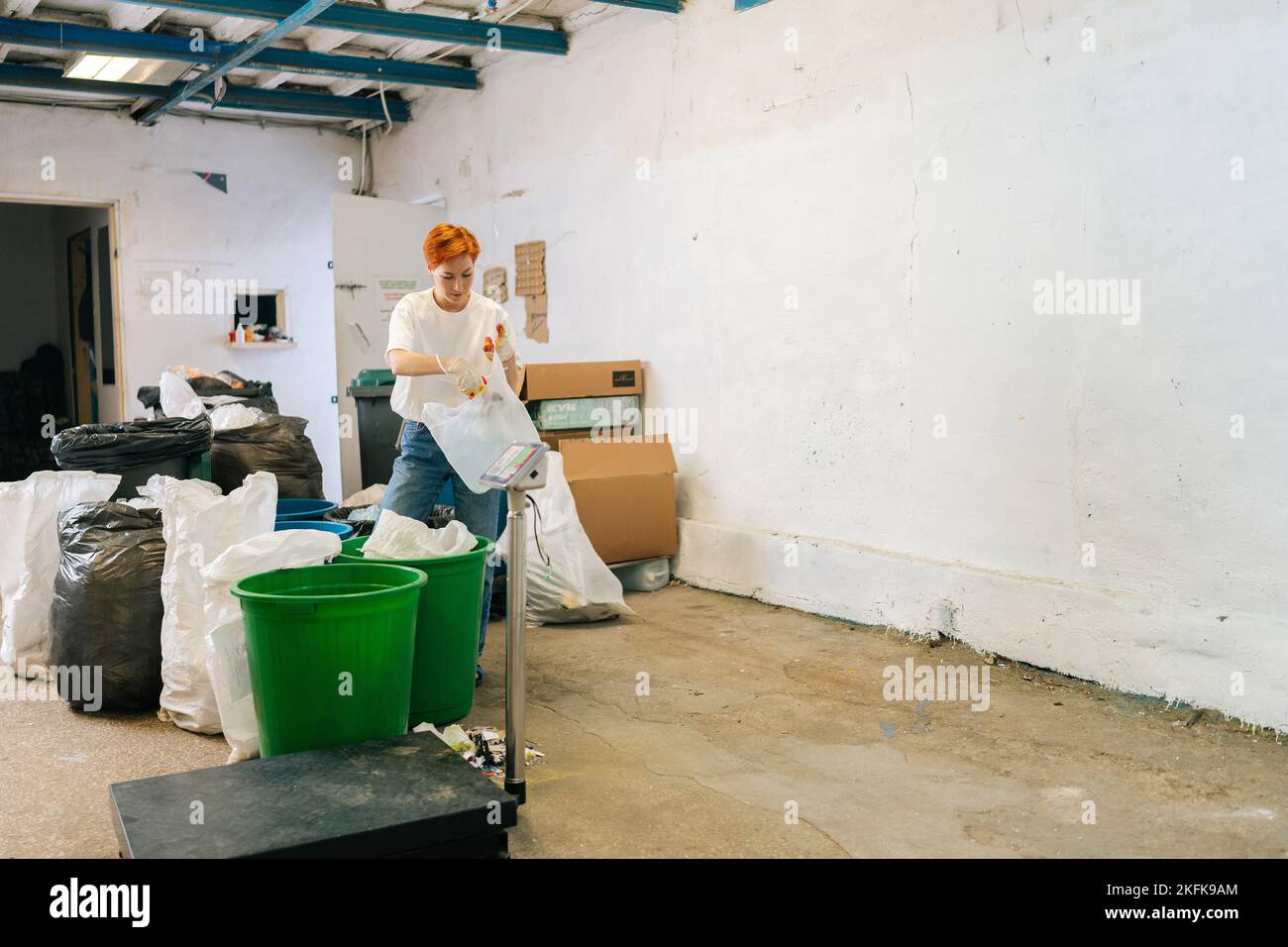 Wide shot of professional female worker wearing latex gloves sorting ...