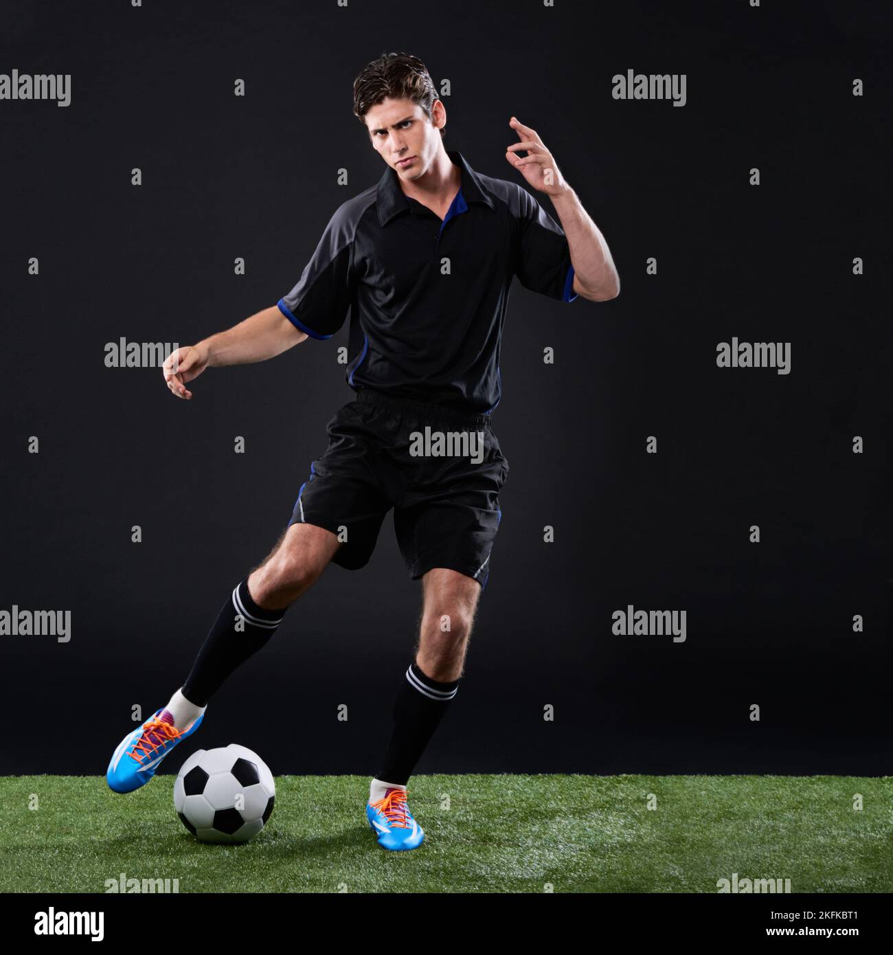 Going for the goal. a handsome soccer player isolated on black Stock ...