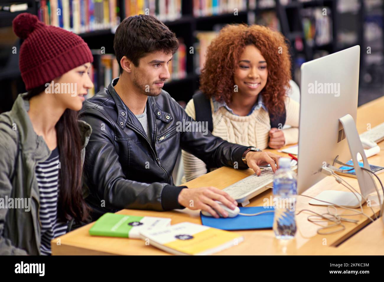 Studying the smart way. a group of students working together at a computer in a university ...