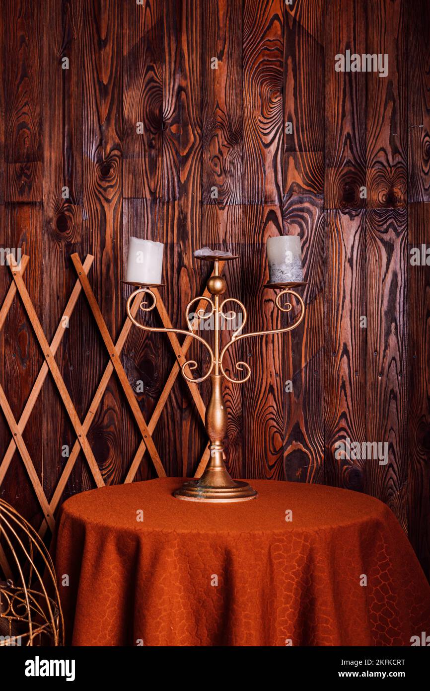 An old candlestick with candles on the table. Loft style in brown tones ...