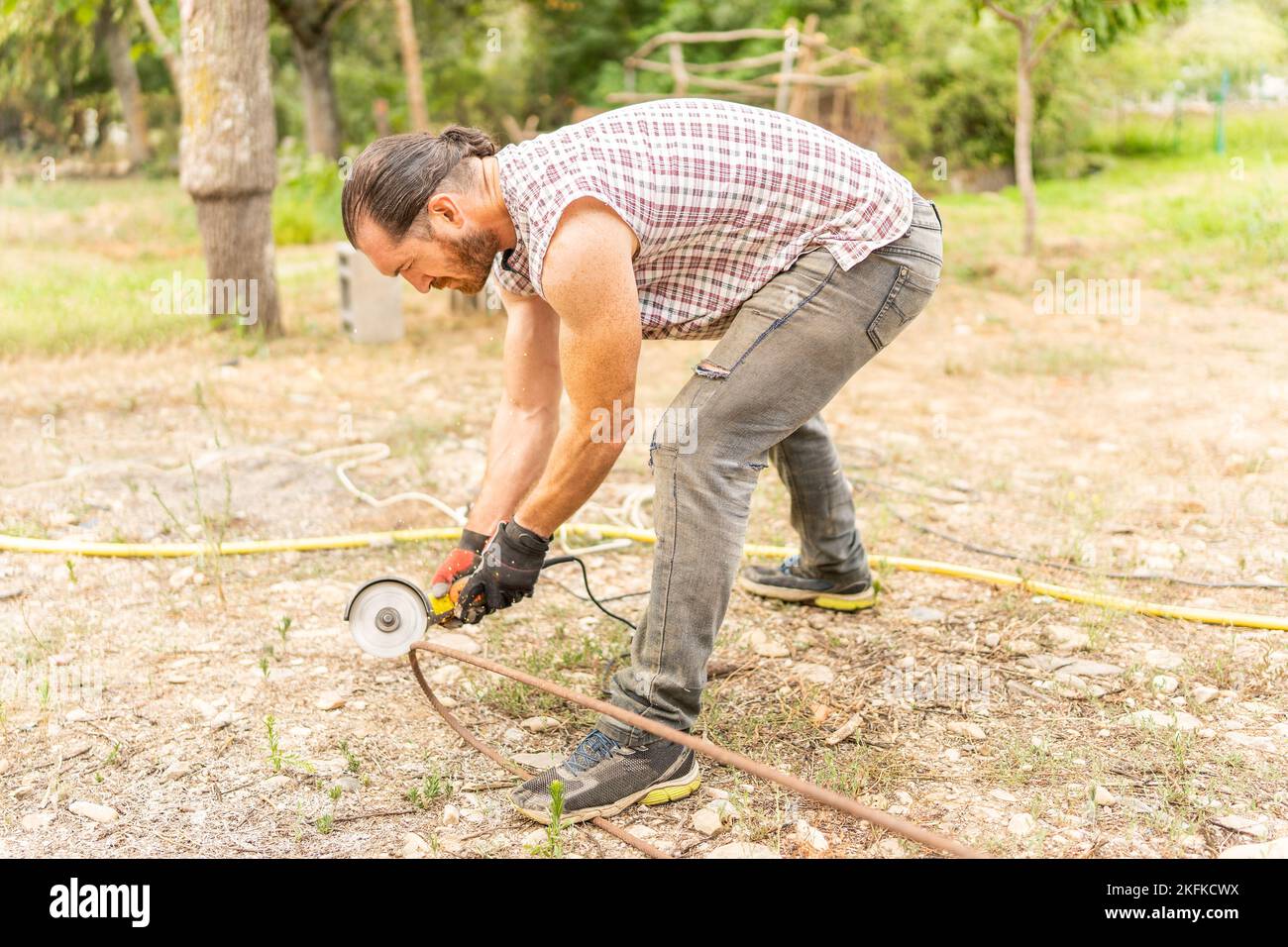 Man cutting a piece of iron using a radial saw Stock Photo - Alamy