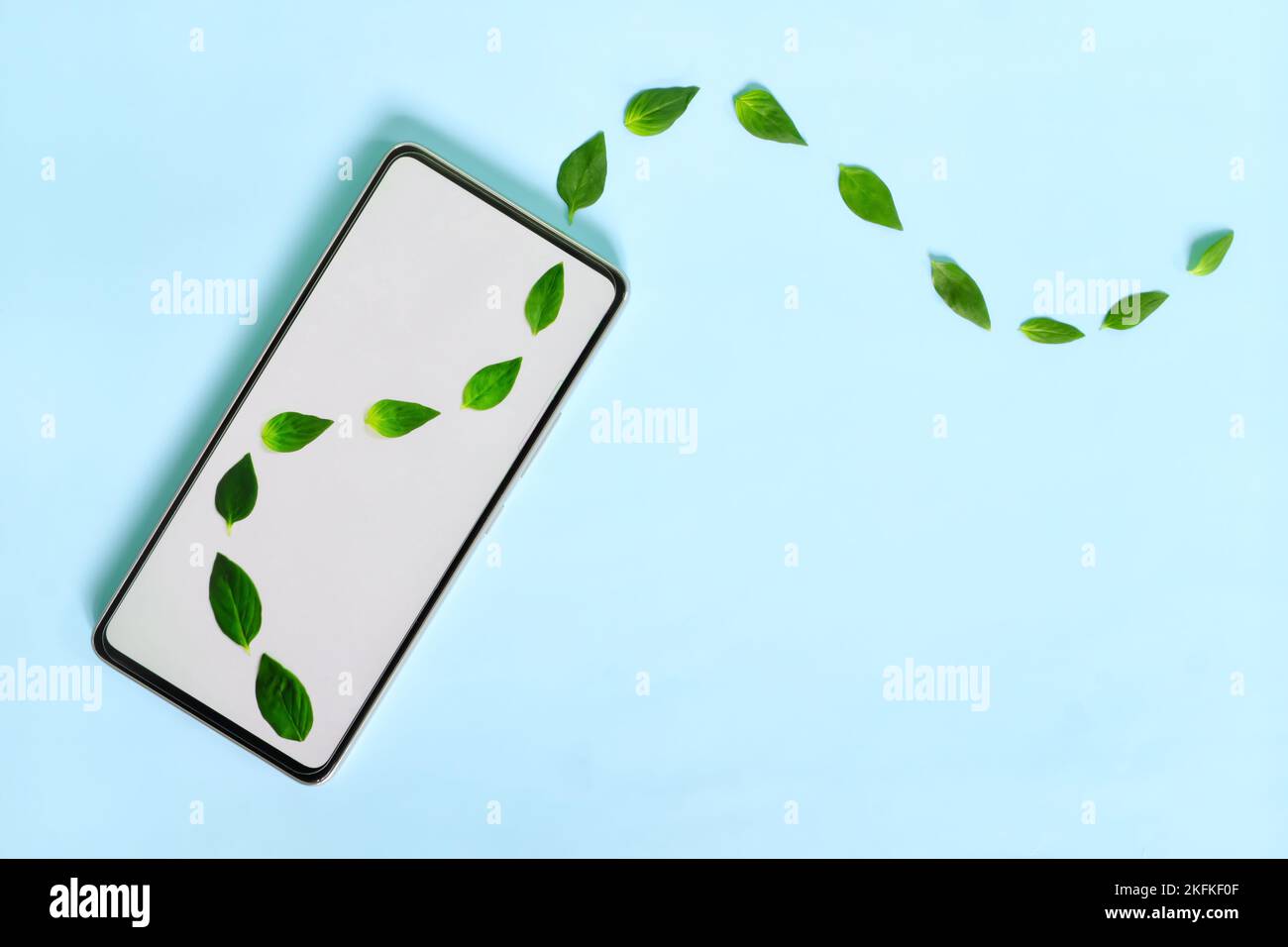 Mobile phone smartphone with fresh green leaves coming out. Environment ...
