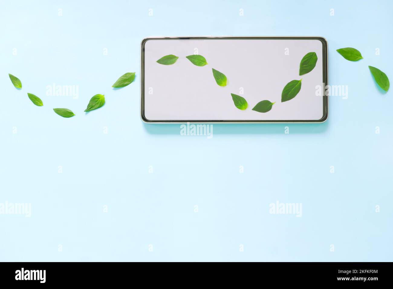 Mobile phone smartphone with fresh green leaves coming out. Environment ...