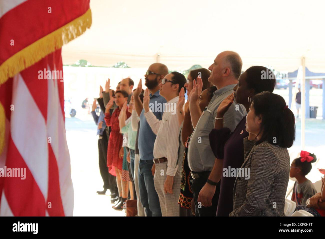 The 16 citizens-to-be stand up in the first row of the International ...