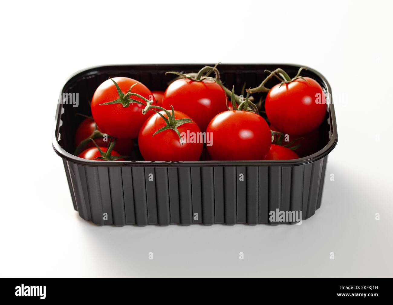 Plastic tray with fresh raw organic red tomatoes on white Stock Photo ...